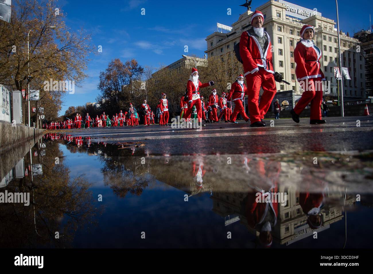 Several people participating in a charity race are reflected in a ...