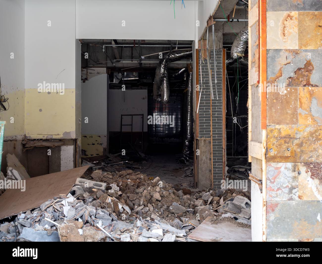Abandoned building interior with broken walls, exposed pipes, and ...