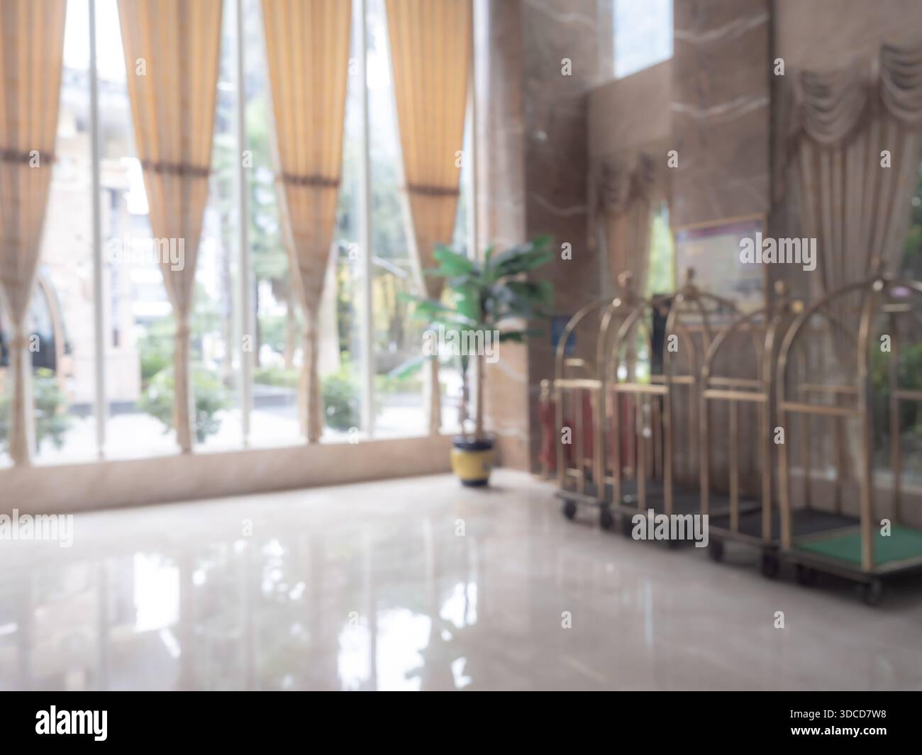 Blurred luxury hotel lobby interior with luggage carts and large and ...