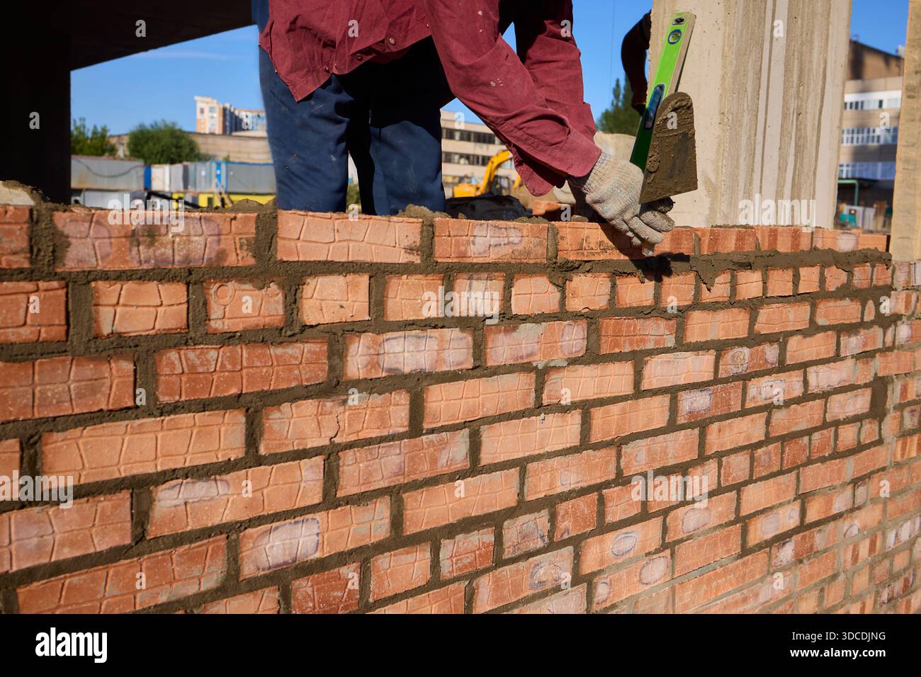 A skilled worker laying bricks at a construction site, showcasing ...