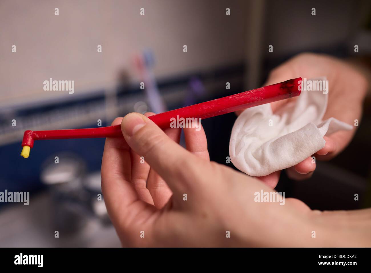 A person cleaning a bright toothbrush with a cloth, emphasizing the ...