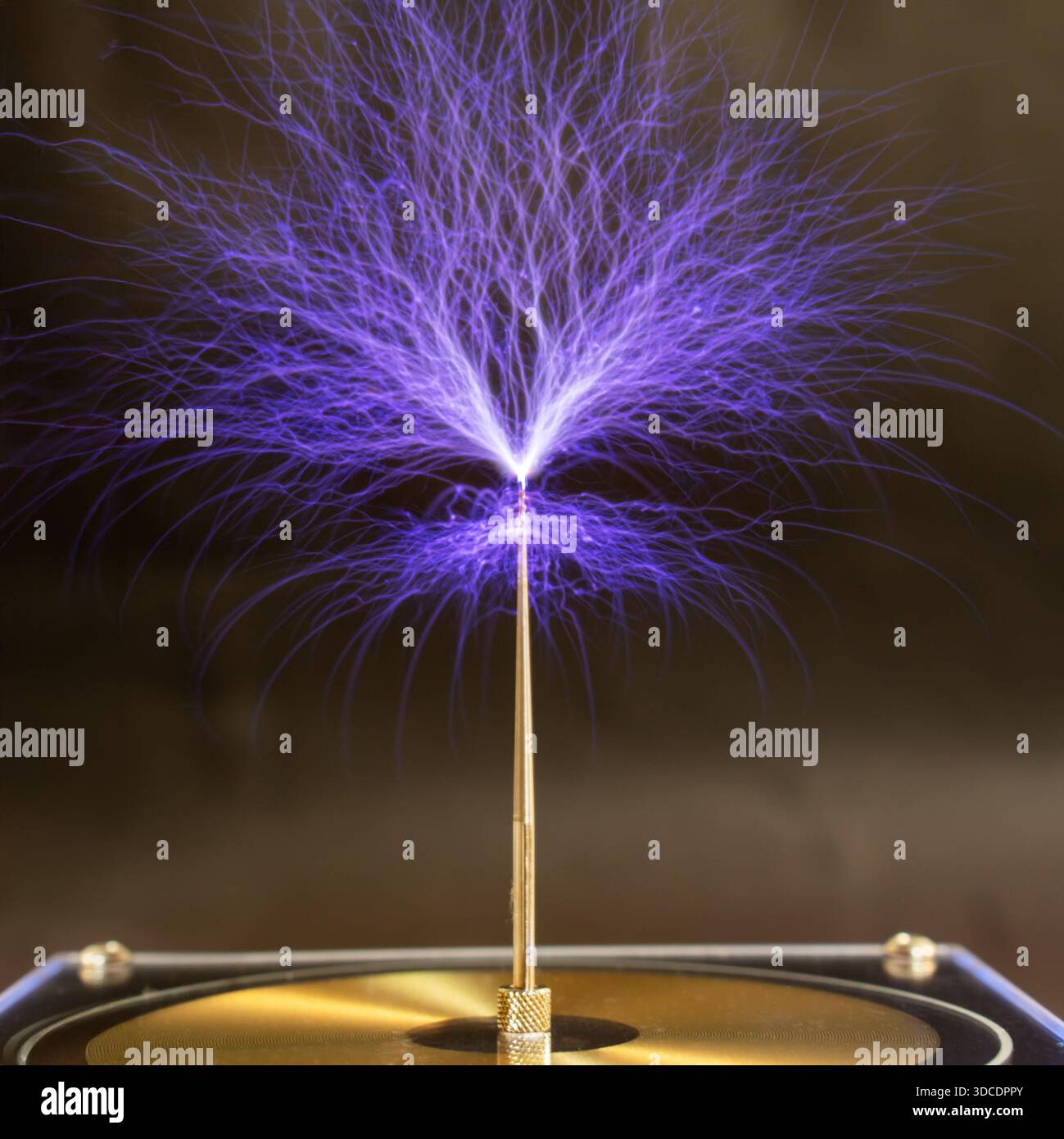 Streams of violet plasma discharge from the top of a Tesla coil in a ...