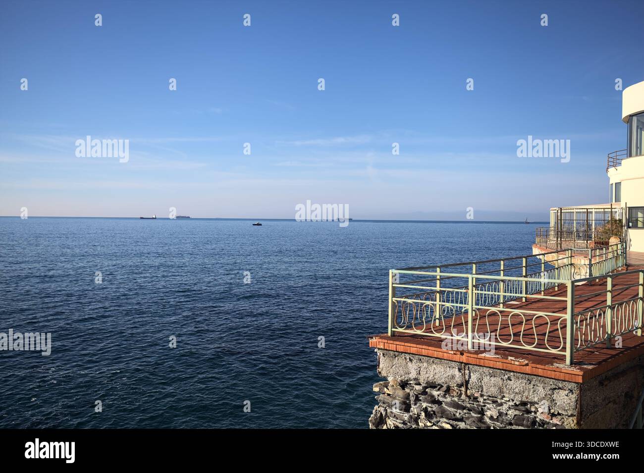 Promenade with an azure railing over a cliff with the sea down below ...
