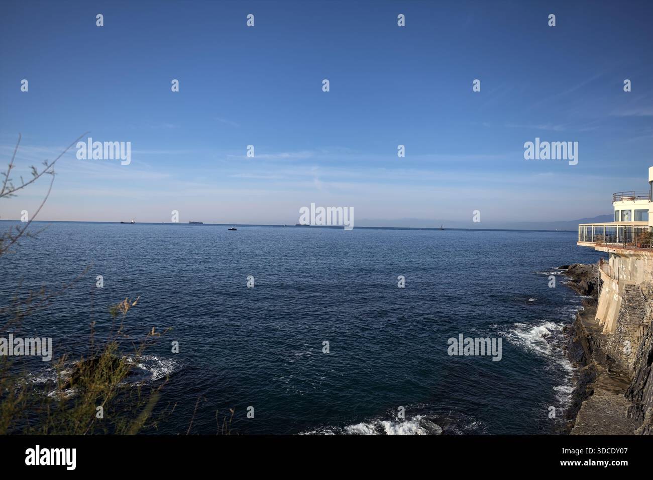 Promenade with an azure railing over a cliff with the sea down below ...