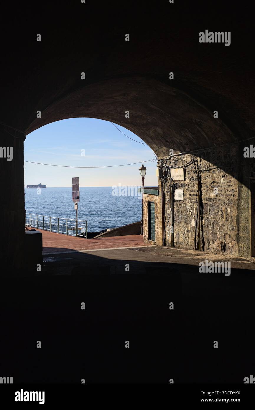 Promenade on a cliff by the sea on a sunny day seen from a covered ...