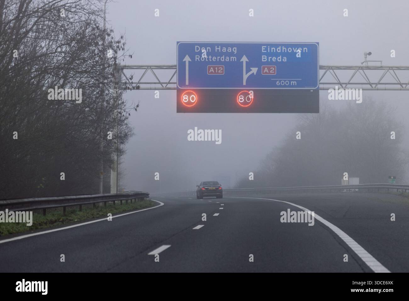 A misty highway scene in the Netherlands with overhead matrix signs ...