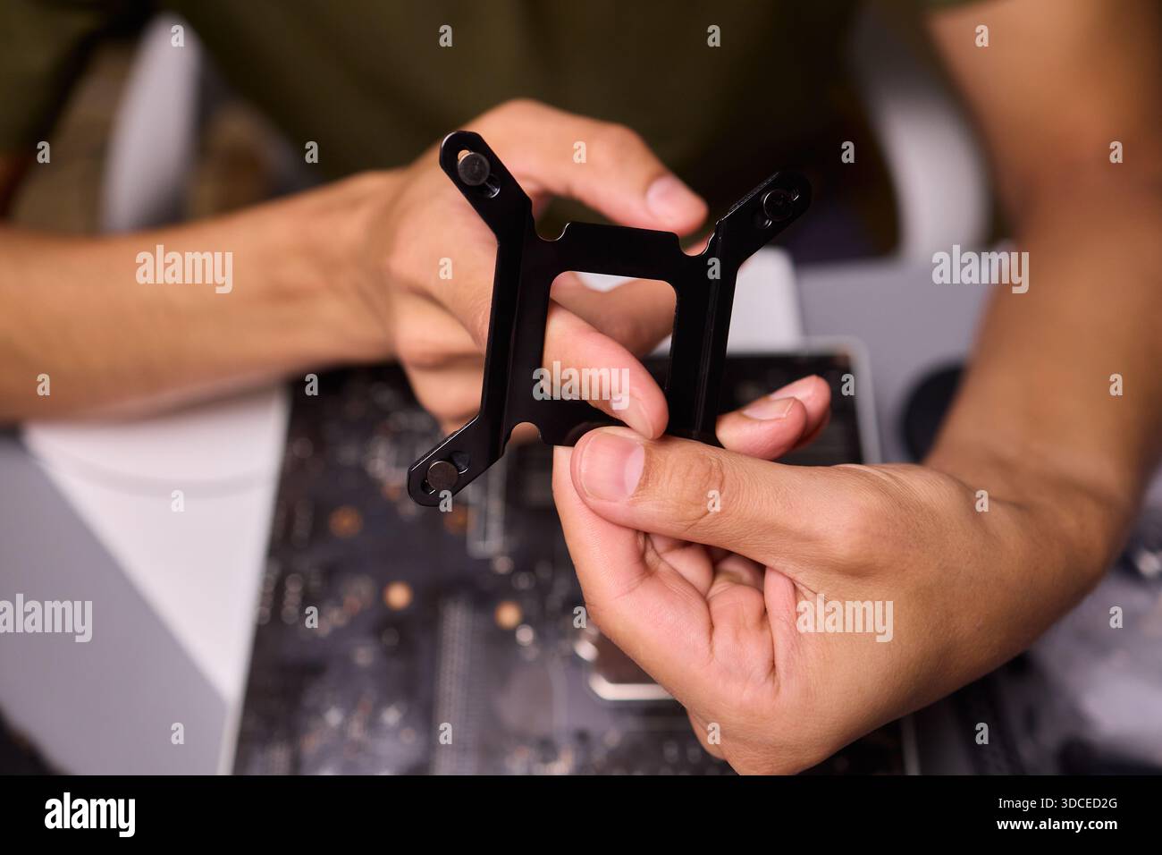 Closeup of hands holding a black mechanical component, showing assembly ...