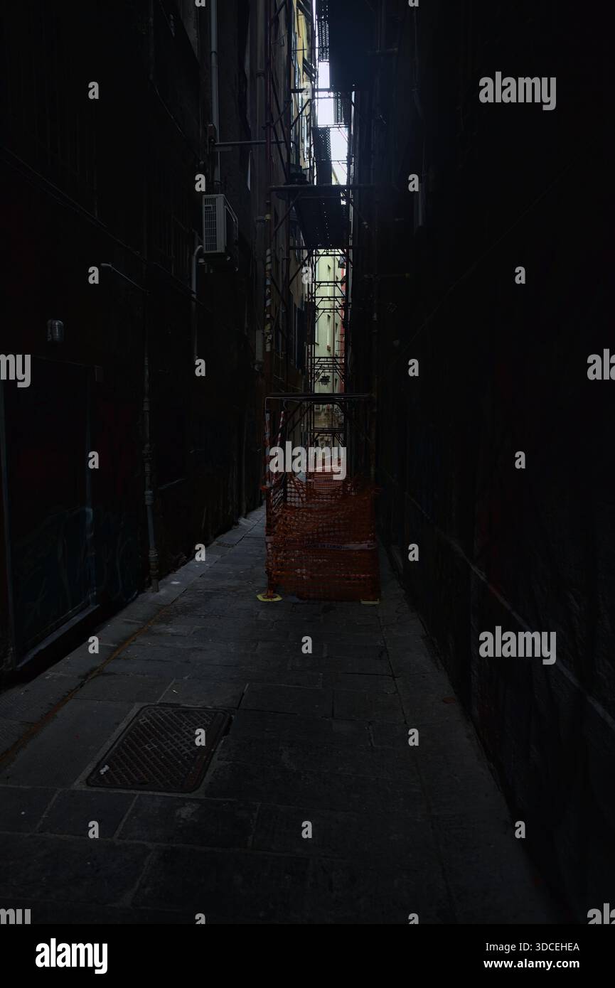 Alley in shade with a scaffolding in the middle of it and a clear sky ...