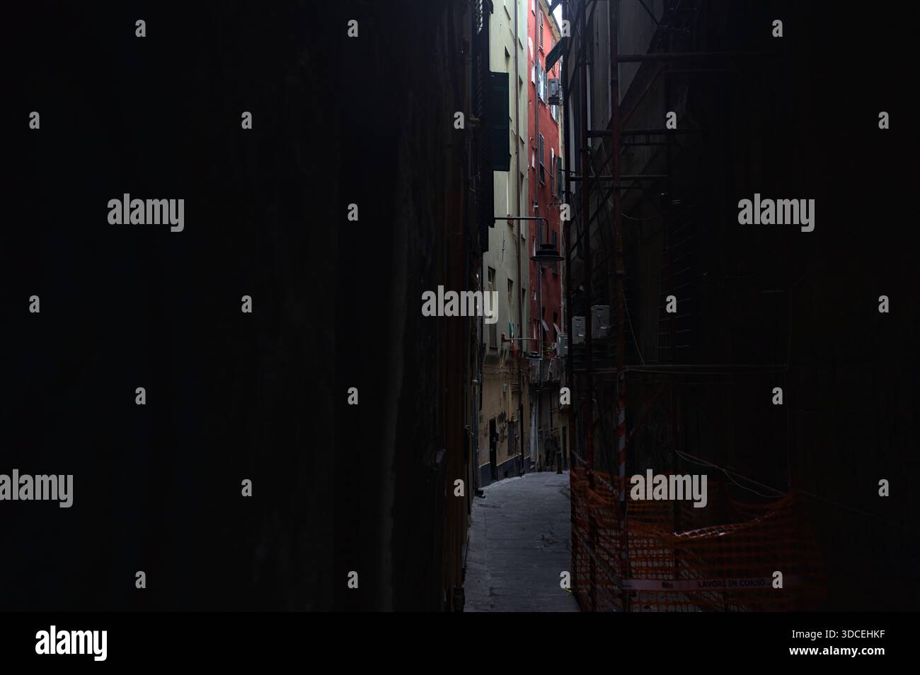 Alley in shade with a scaffolding in the middle of it and a clear sky ...