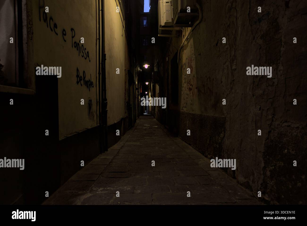 Very narrow alley with a few graffiti and overhead street lamps, and an ...