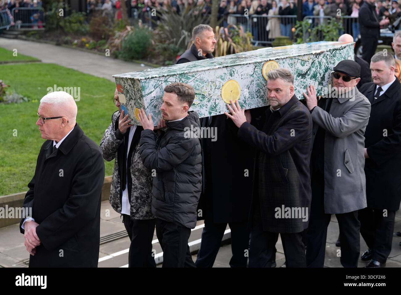 The bearer party carry the coffin decorated in the iconic artwork 'Bye ...