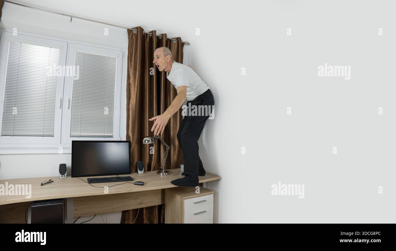 Senior citizen fixing curtain rod. Pensioner standing on the desk. Home ...