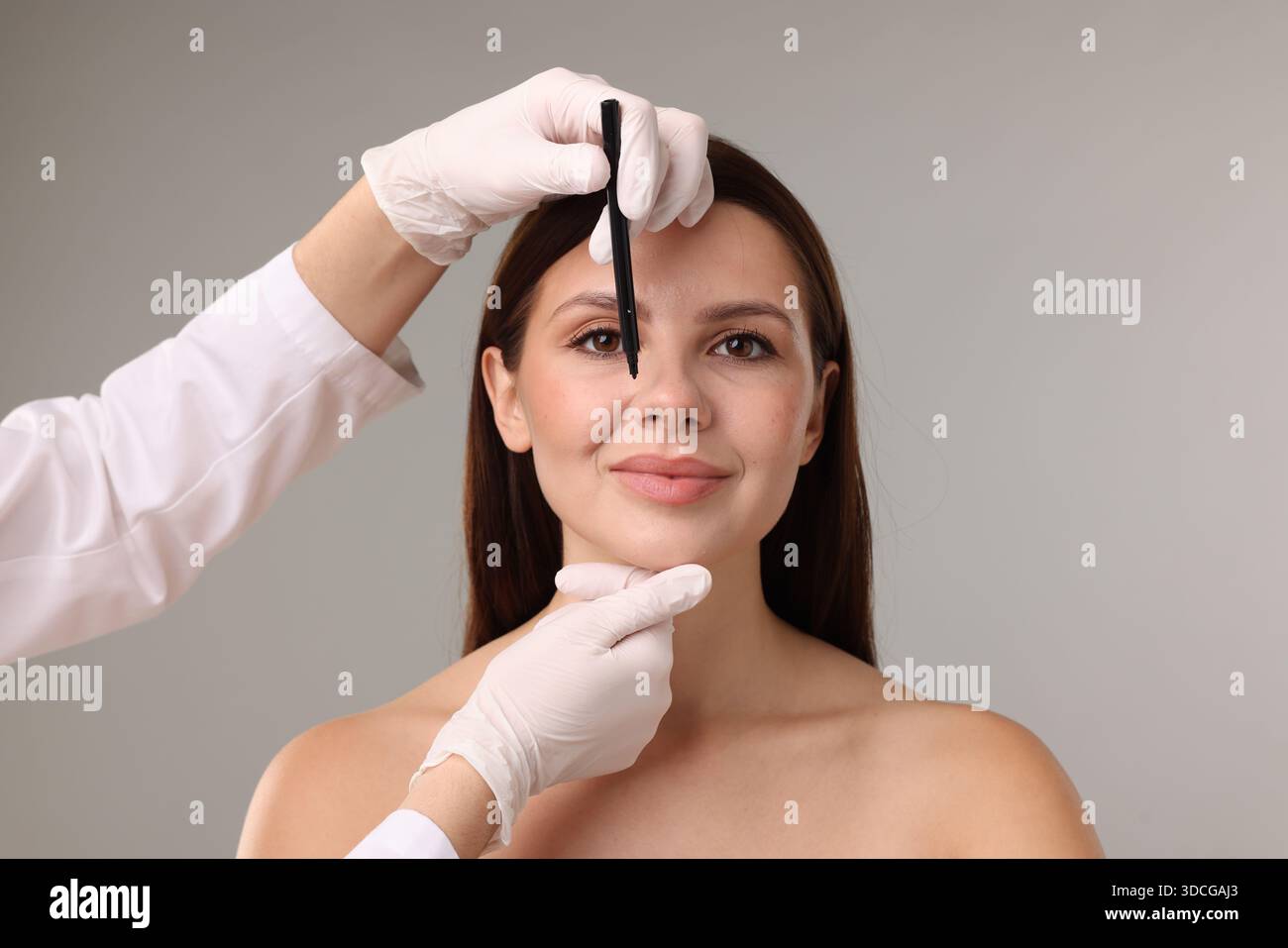 Doctor drawing marks on patient's face for plastic surgery operation ...