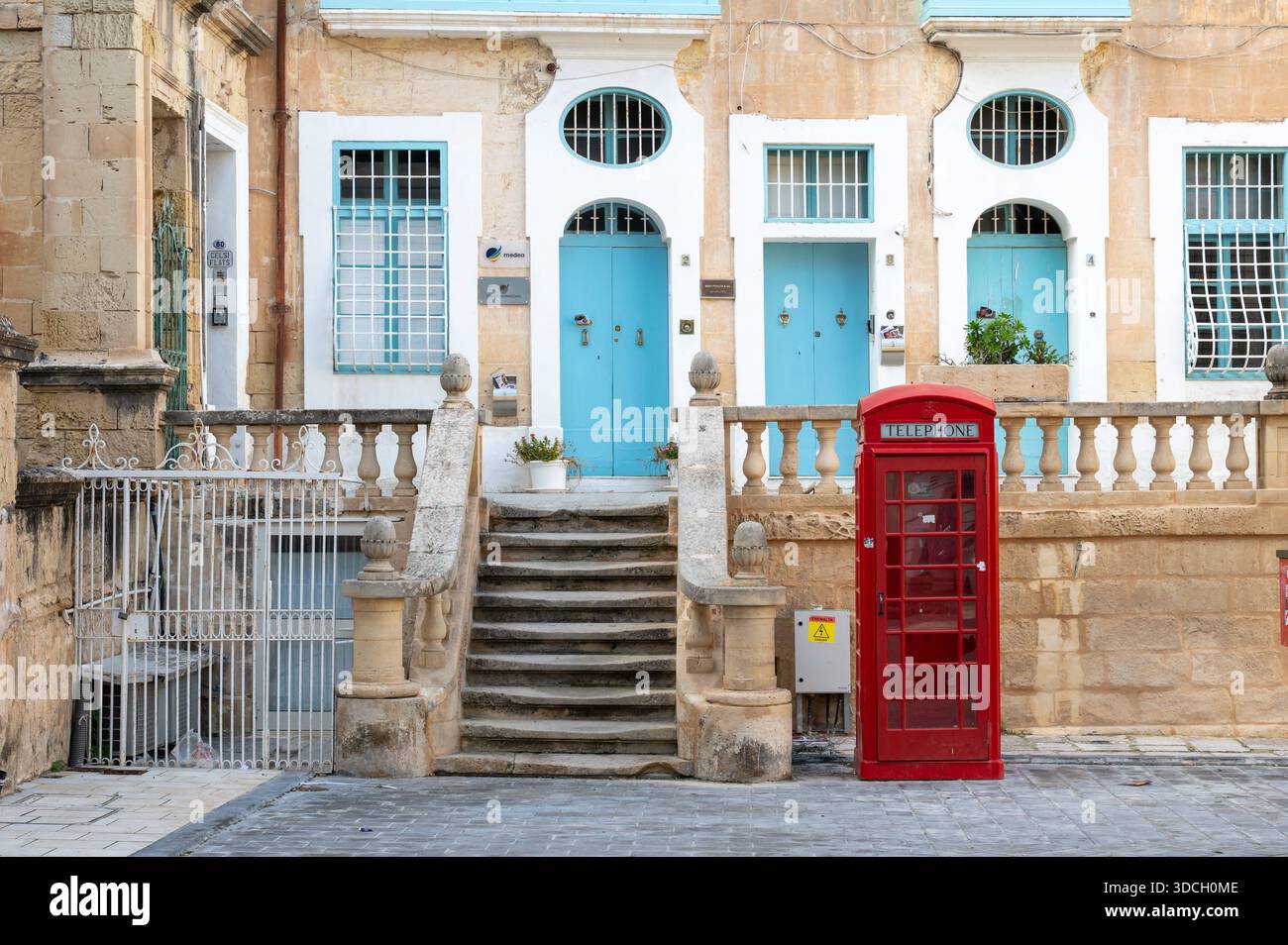 Bright red vintage British-style phone booth in front of a colorful ...