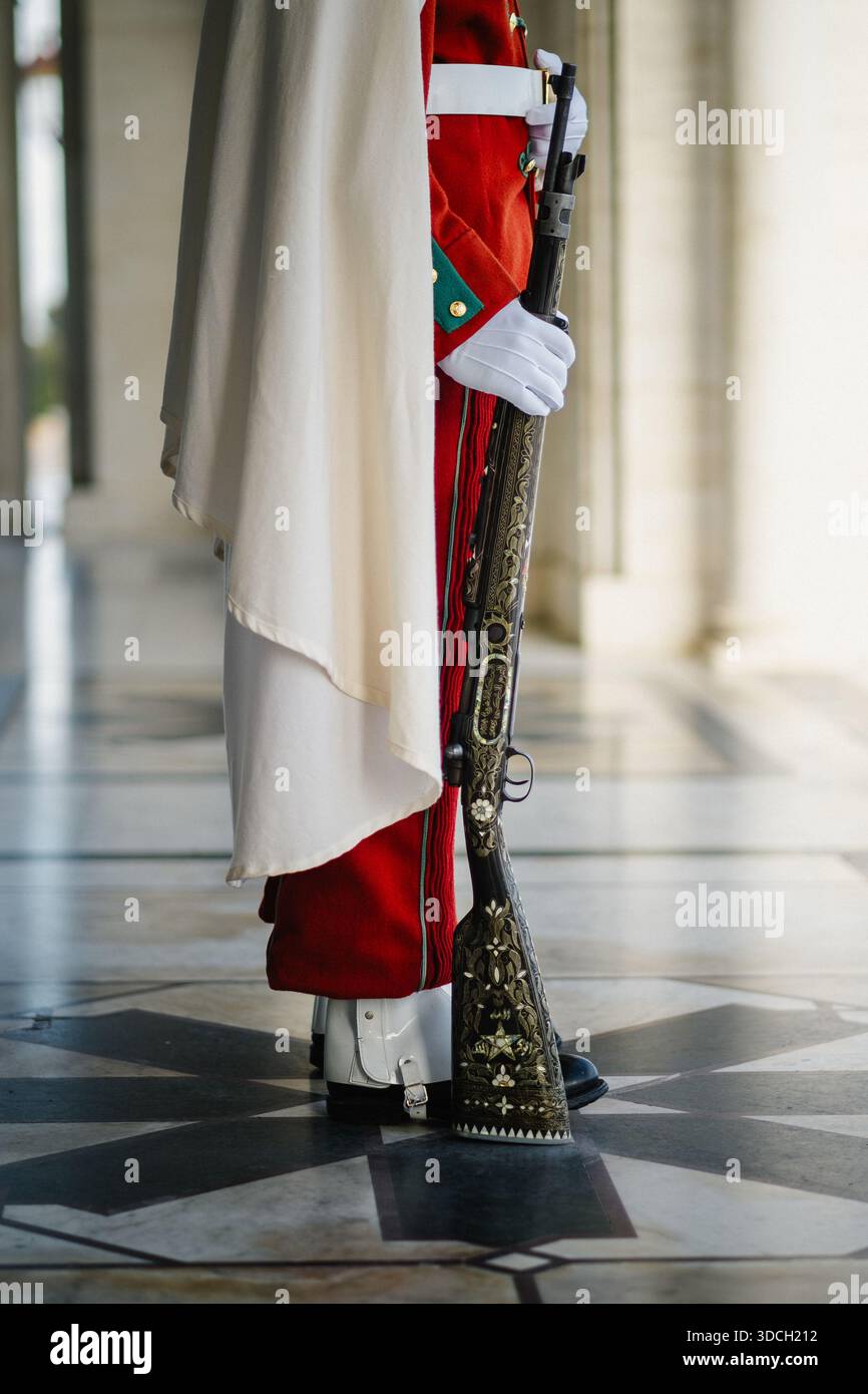 Ceremonial guard standing indoors, holding an ornate engraved rifle ...