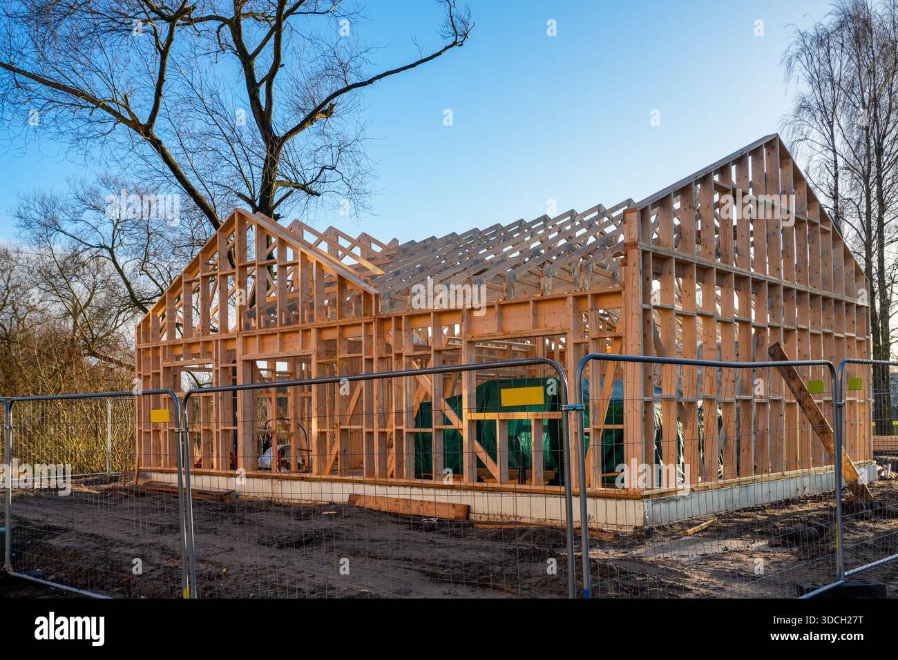 Wooden house frame under construction with roof trusses on a ...