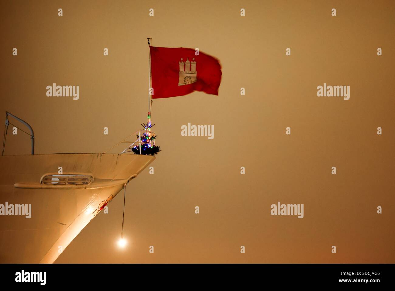 23 December 2025, Hamburg: A small illuminated Christmas tree stands on ...