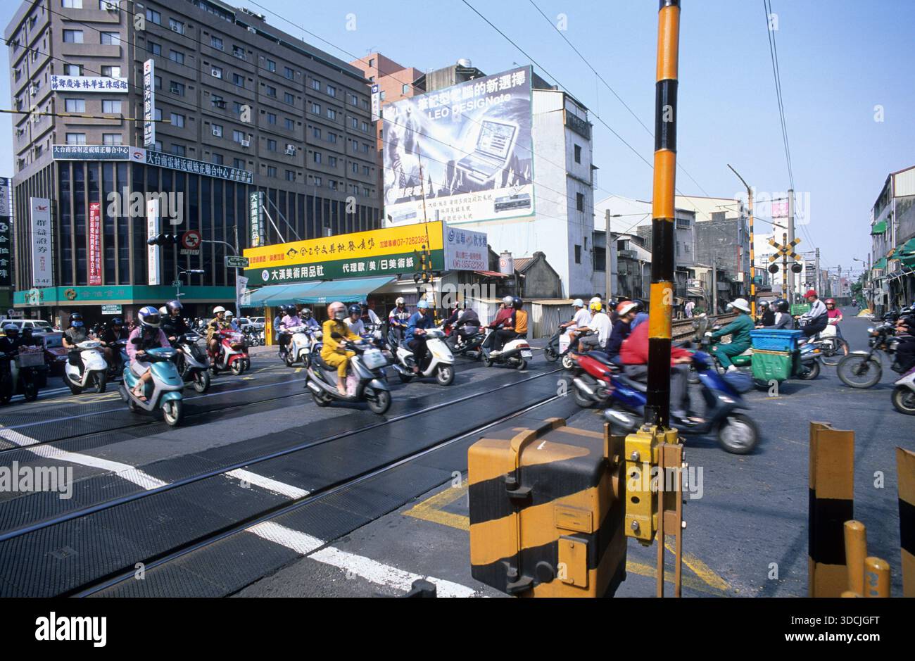 Taiwan, Taipei, Vespas crossing train line in general street scene ...