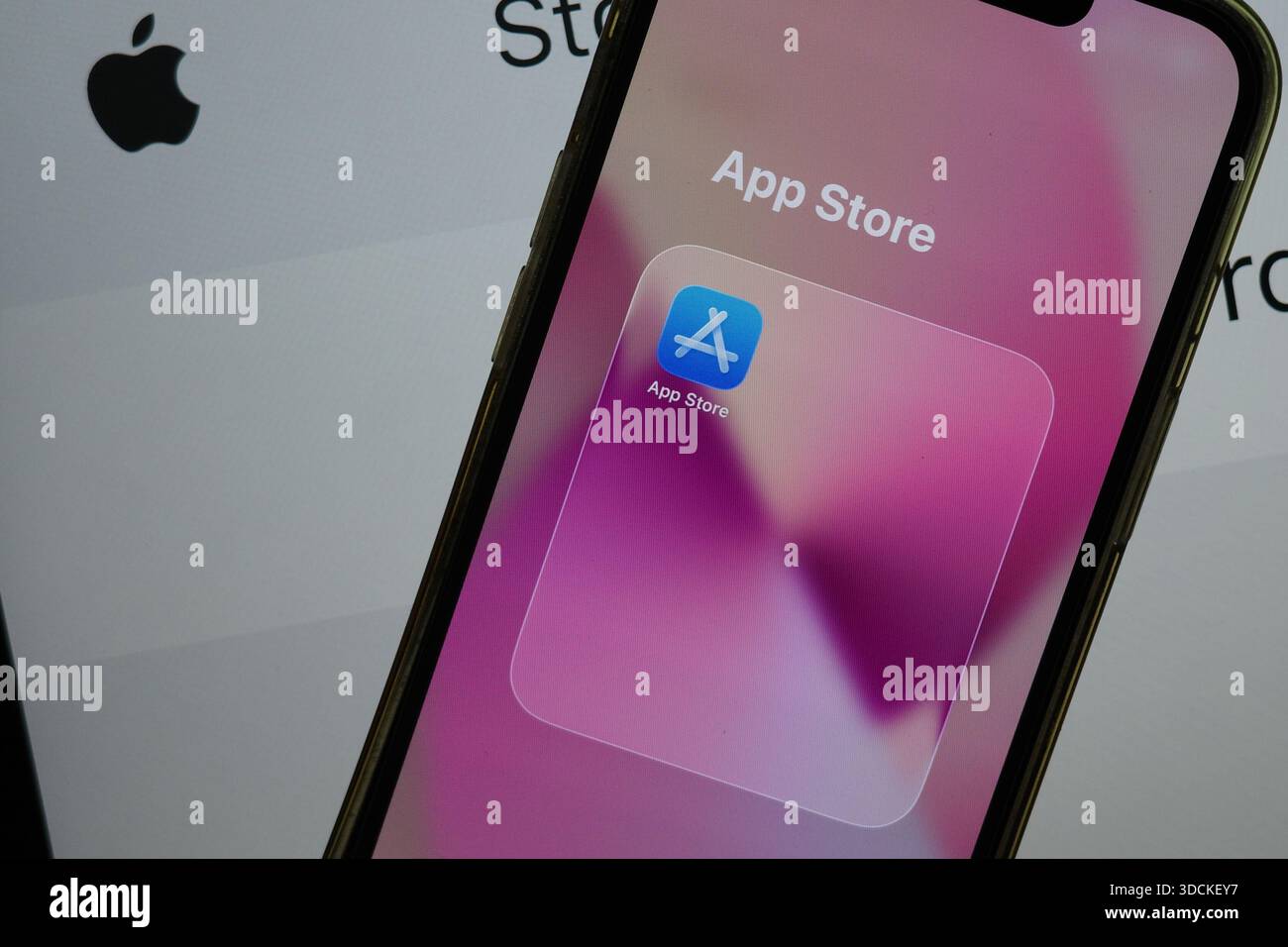 A smartphone displays the App Store icon in front of Apple-related ...