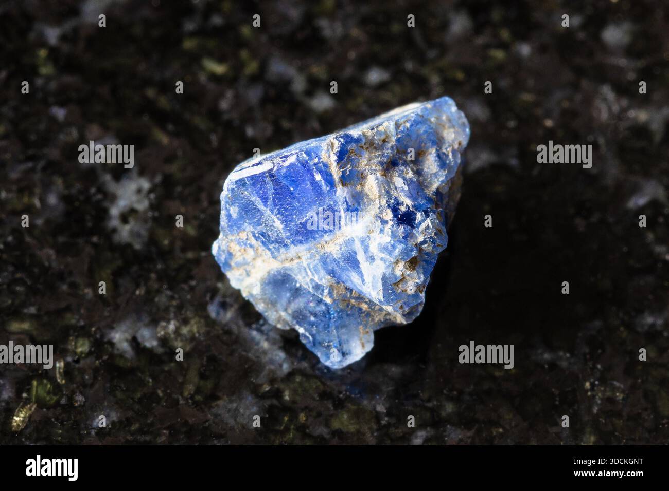 sample of raw benitoite mineral on black granite background close up ...