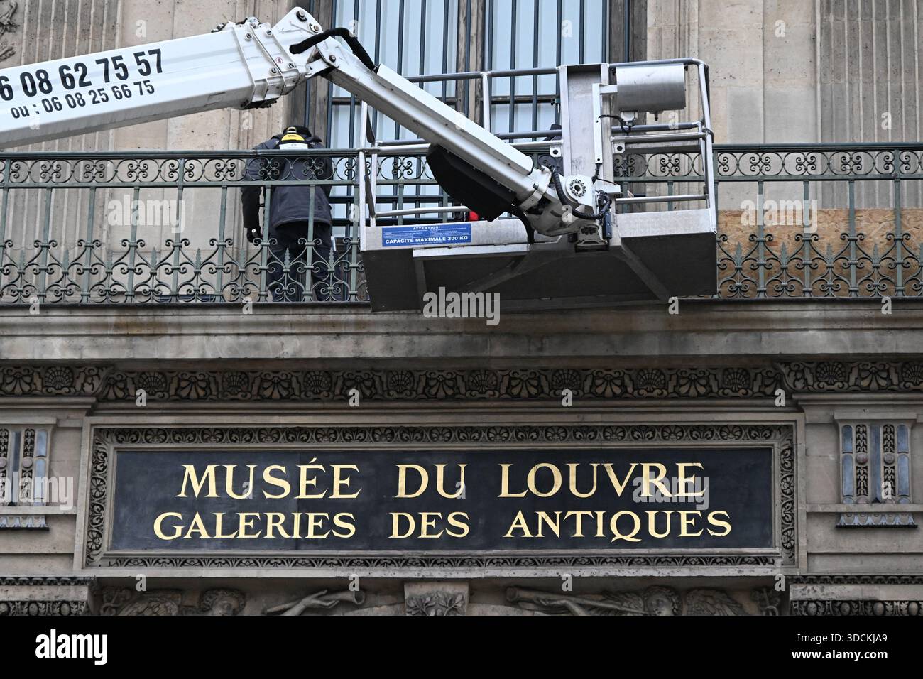 Workers install metal security bars over the window where thieves broke ...