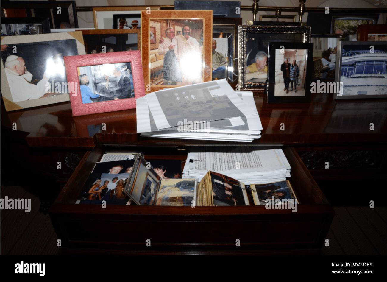 Framed photos on a desk including photos of the Pope, Donald Trump and ...