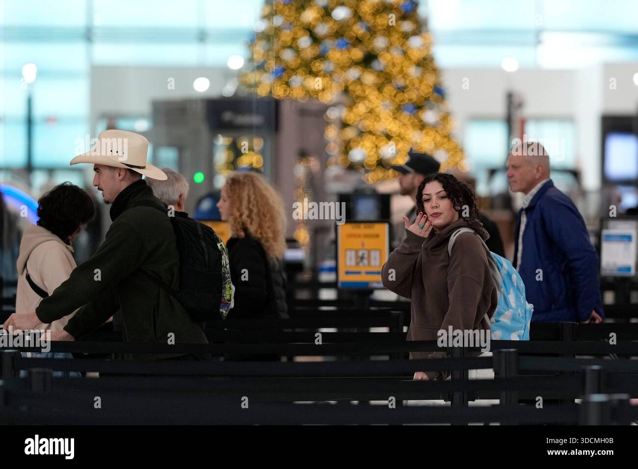 A traveler blows a kiss as she enters a security checkpoint at the ...