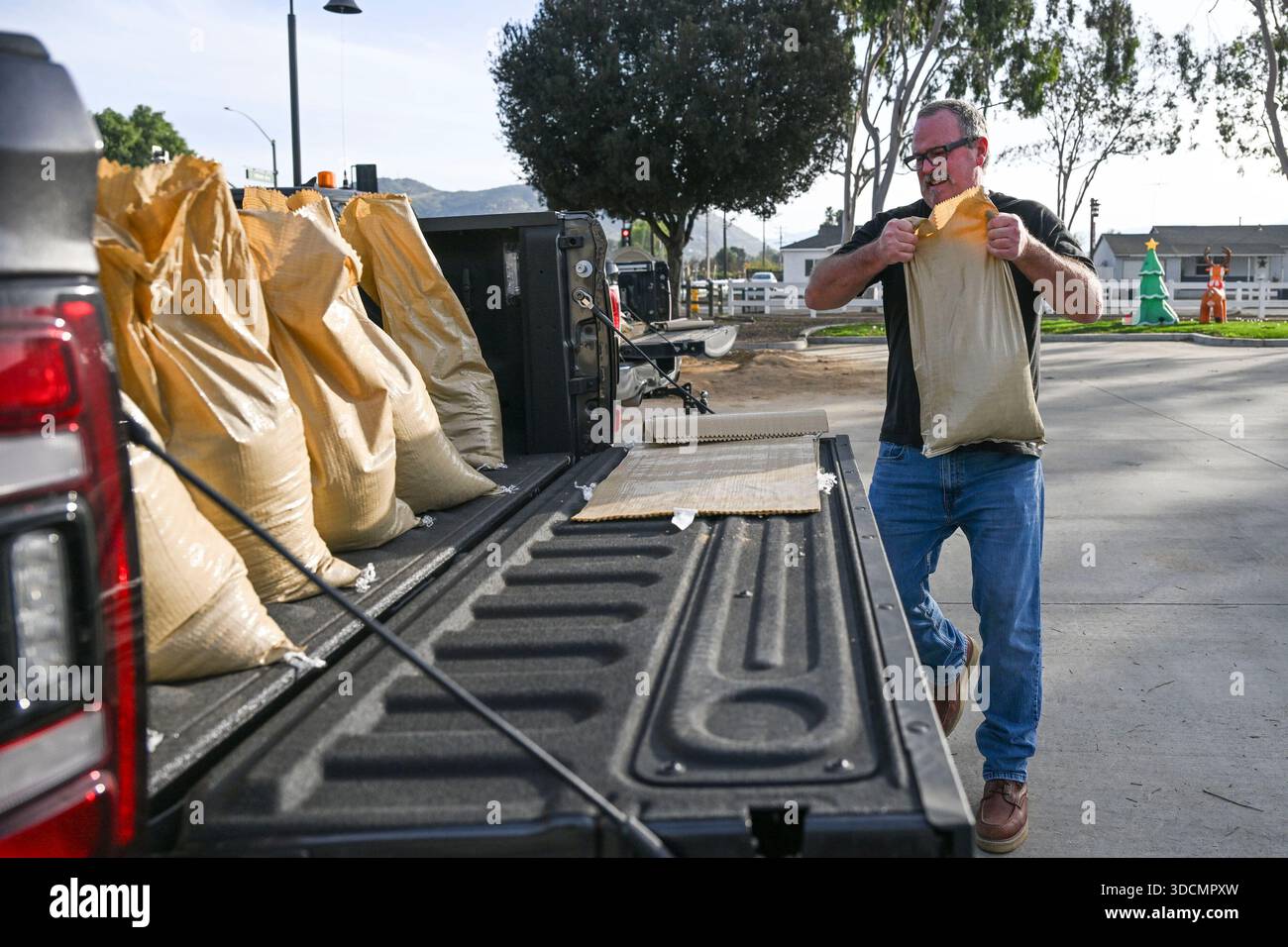 Norco resident Terry McCauley fills his truck with sandbags at the ...