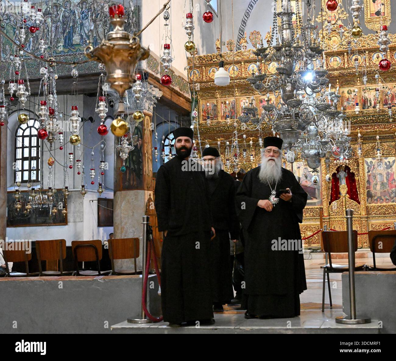 Greek Orthodox priests stand in the Church of Nativity, where tradition ...