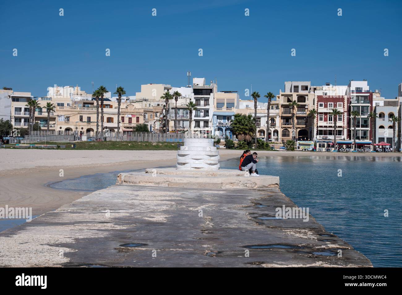Small sandy beach and calm sea with apartment blocks and seaside ...