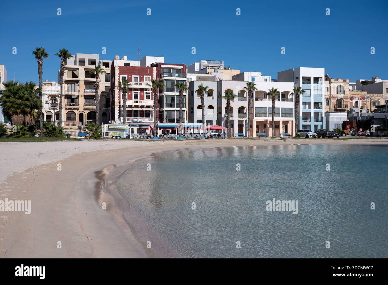 Small sandy beach and calm sea with apartment blocks and seaside ...