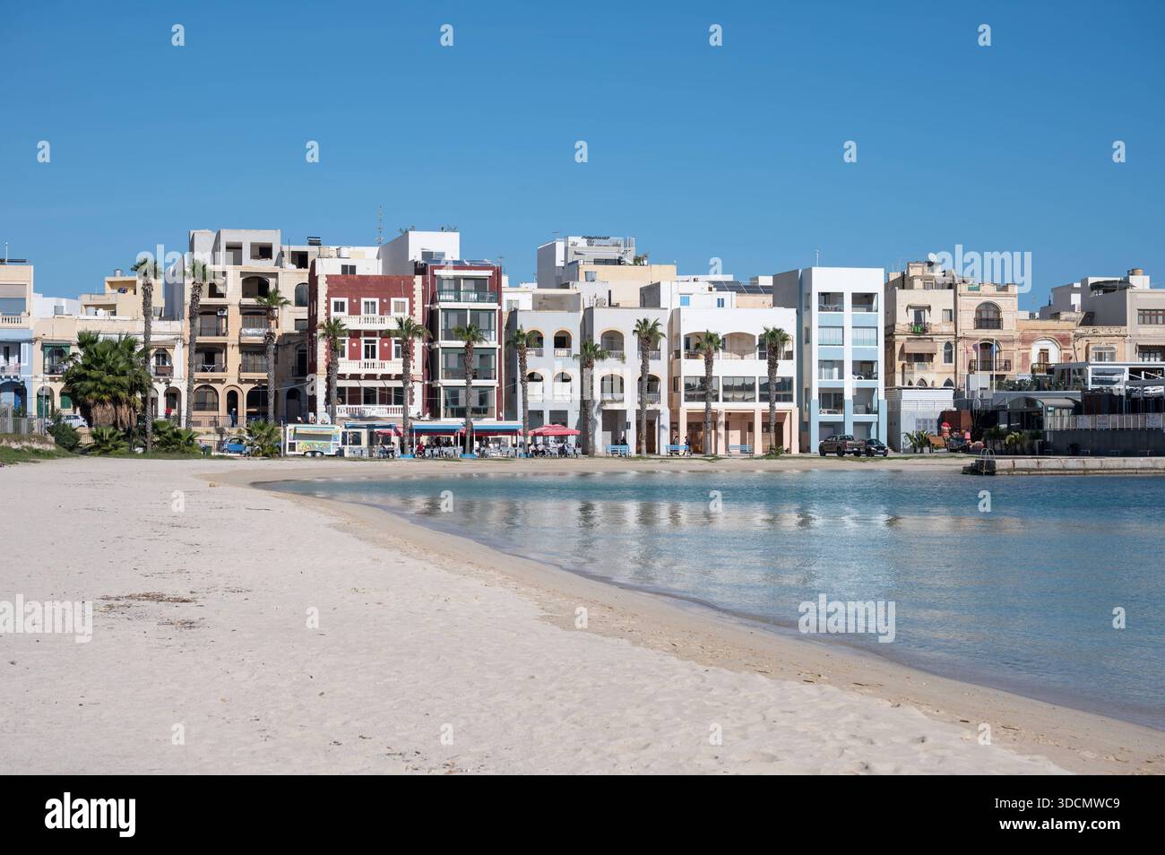 Small sandy beach and calm sea with apartment blocks and seaside ...