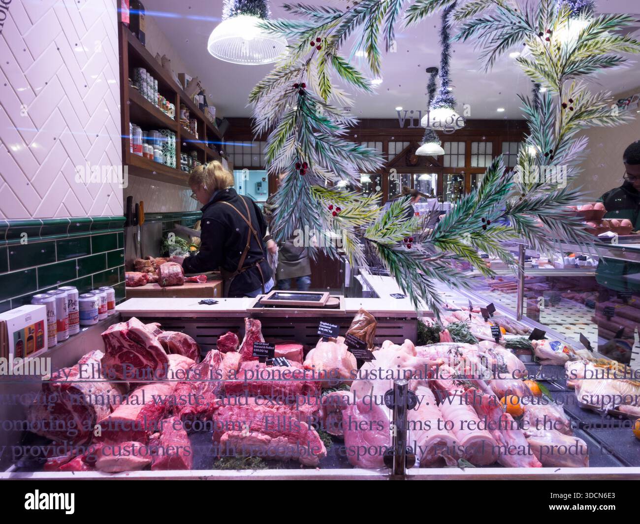 London, England – Butcher shop staff with Christmas decorated chilled ...
