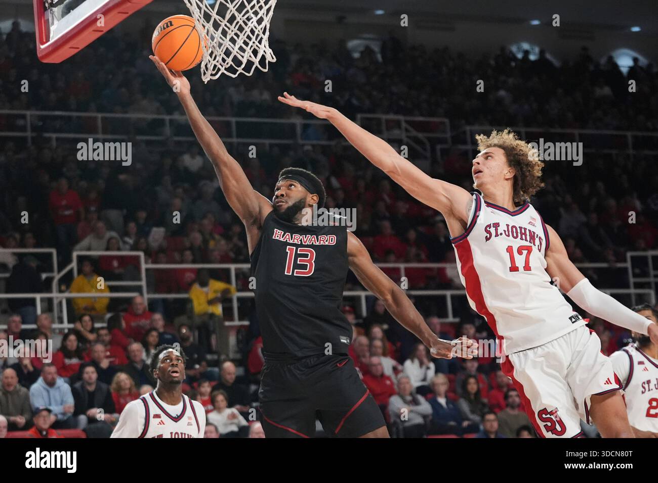 Harvard's Chandler Pigge (13) drives past St. John's Rubén Prey (17 ...