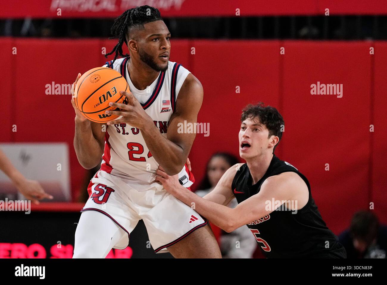 Harvard's Ben Eisendrath (5) defends St. John's Zuby Ejiofor (24 ...