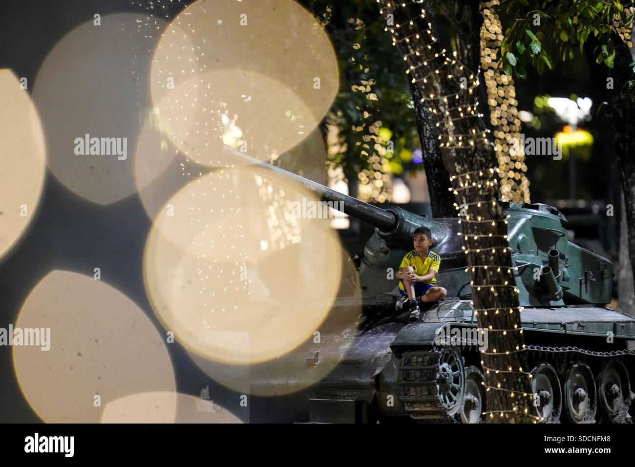 A child sits on an armored vehicle on display among Christmas lights in ...