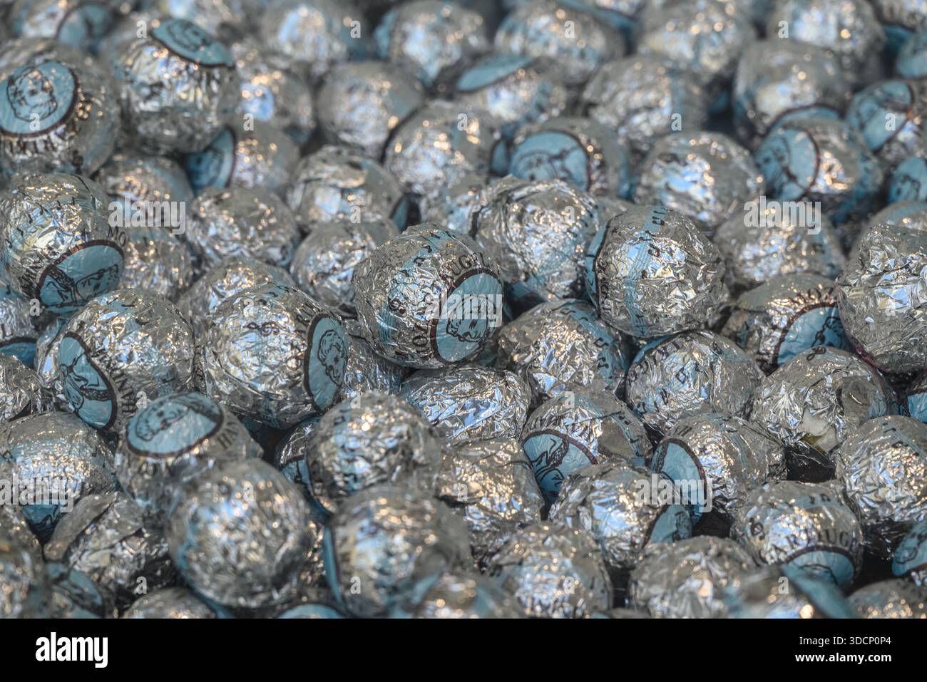 A pile of silver foil-wrapped Mozartkugel chocolate candies in a ...