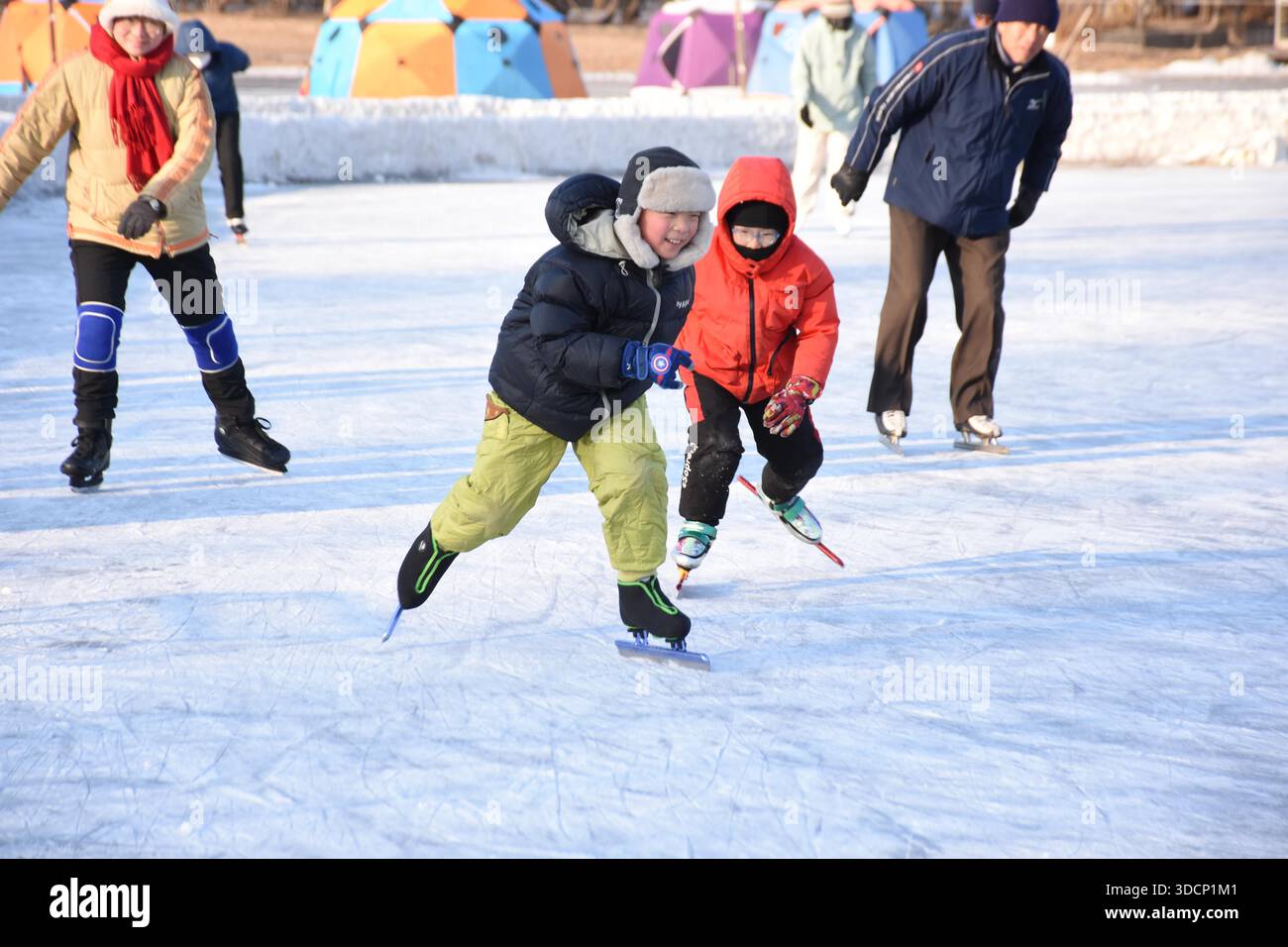 People enjoy skating at an ice rink in Harbin City, northeast China's ...