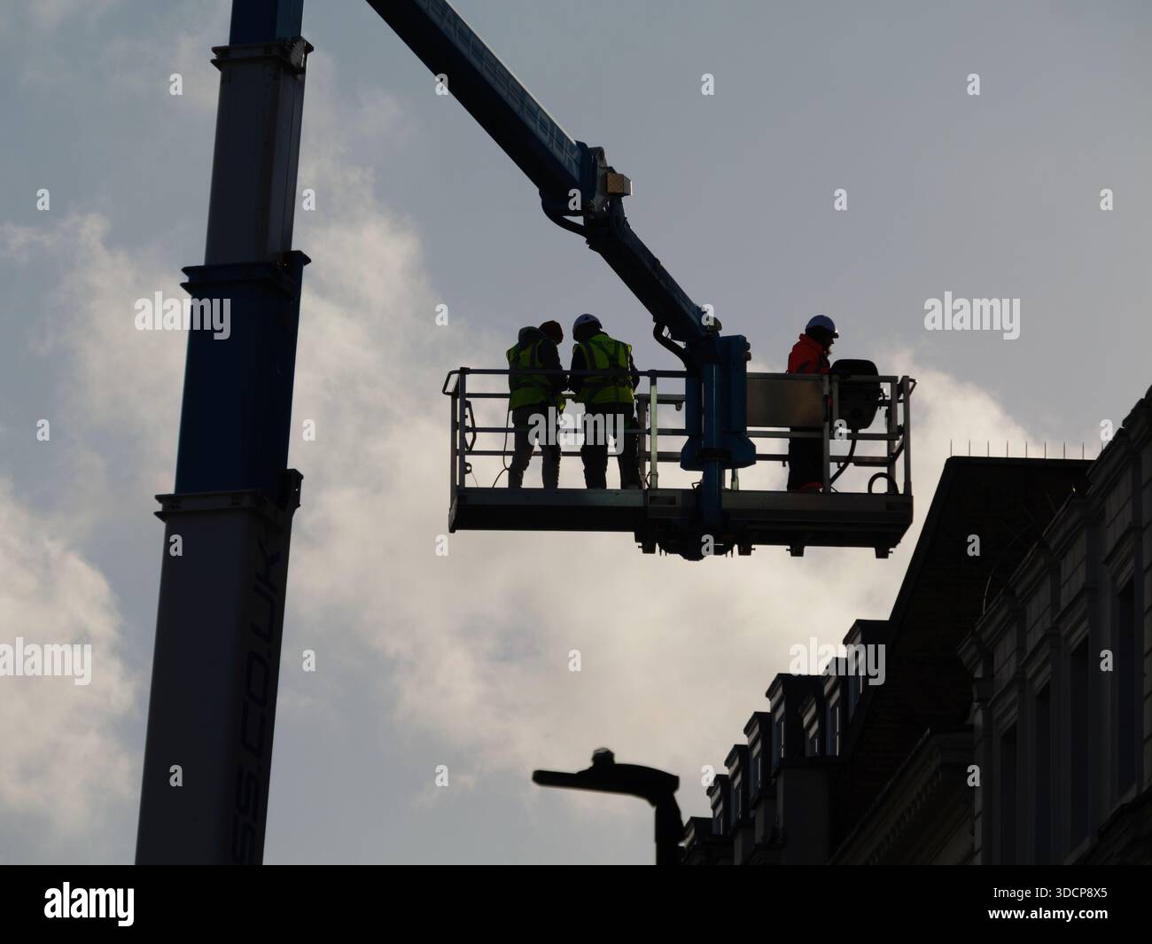 A boom lift, also known as a cherry picker, carries a group of ...