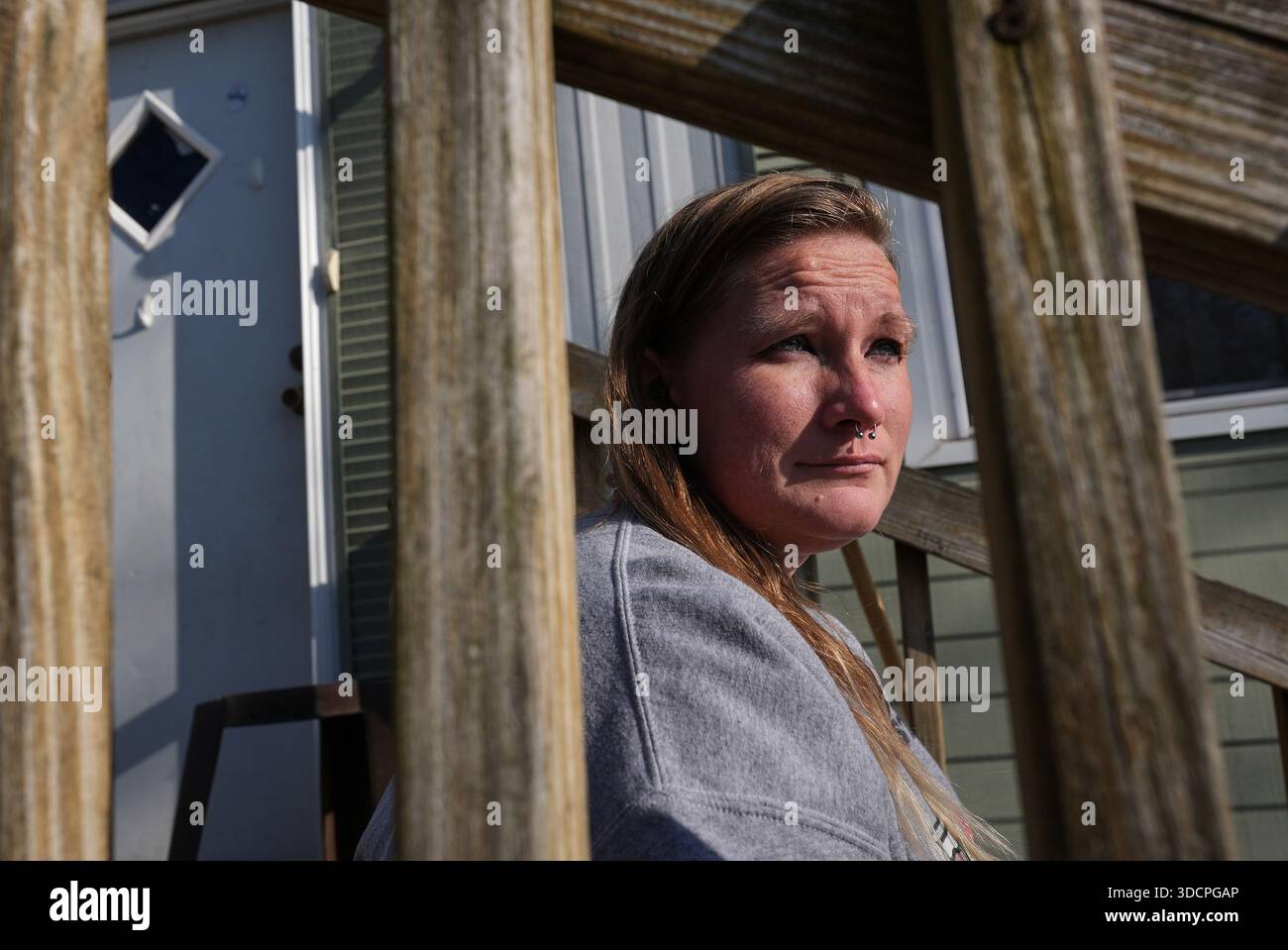 Dianna Tompkins sits on a stair in front of her home in Demotte, Ind ...