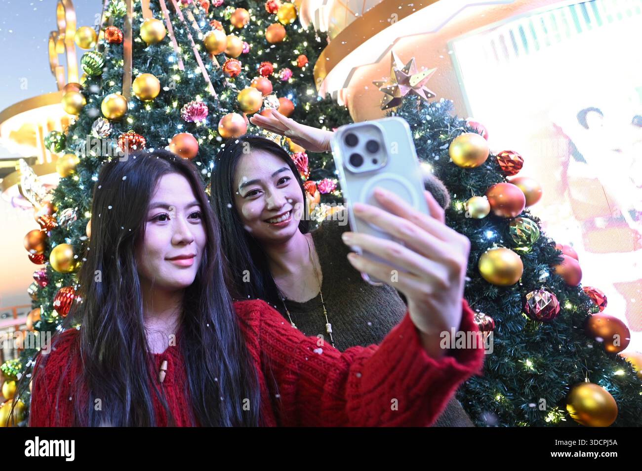 Two ladies posing photo in front of the Christmas decoration at the ...