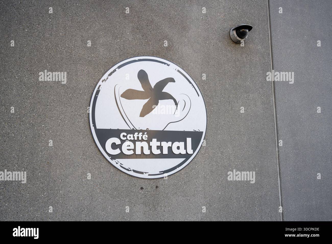 Round Caffe Central logo sign on concrete exterior wall with security ...
