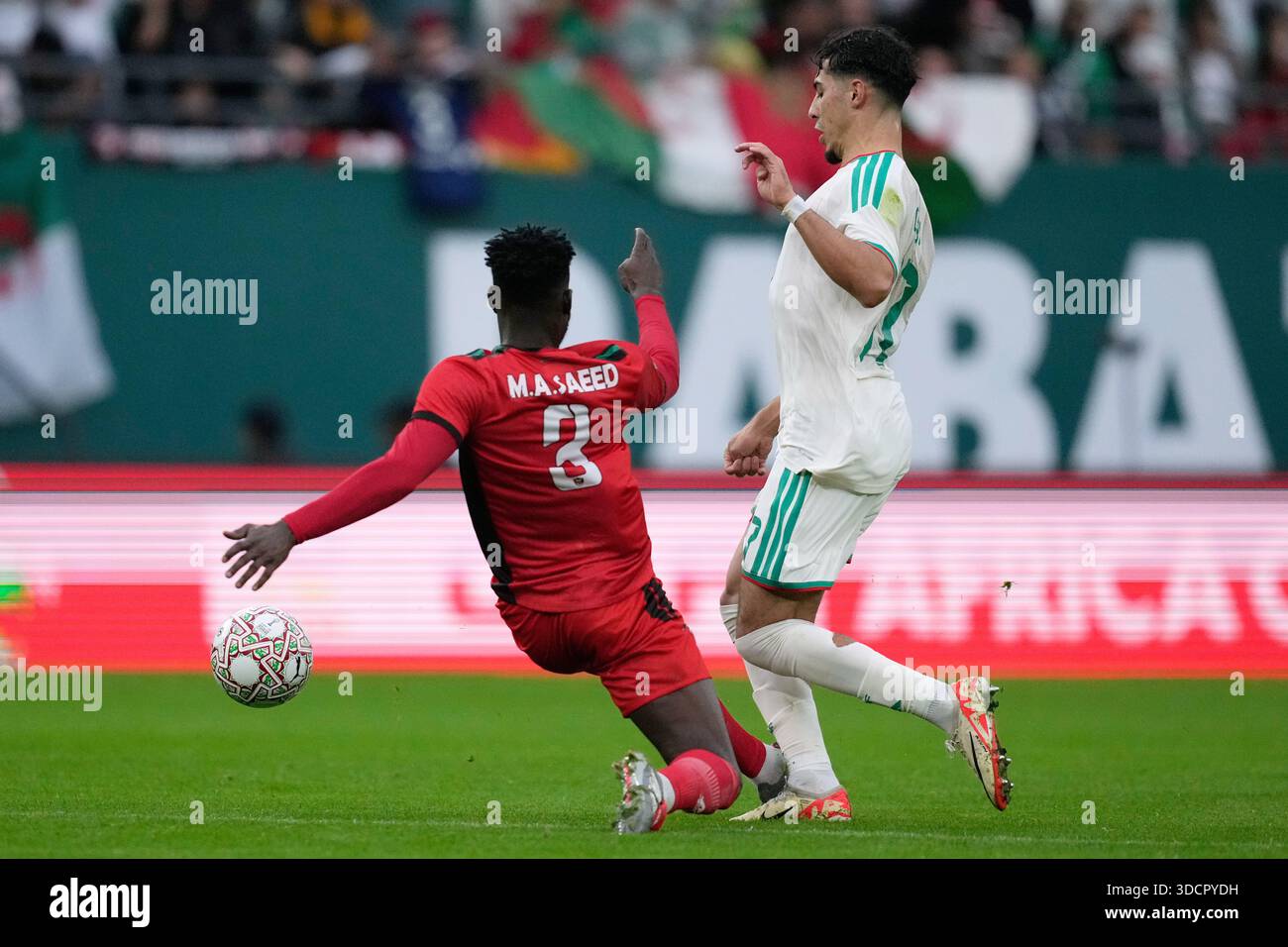 Sudan's Mohamed Saeed Ahmed, left, challenges for the ball with Algeria ...