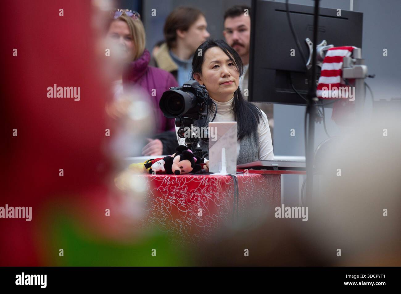 Ginok Song is seen at work taking family photos with Santa at the ...