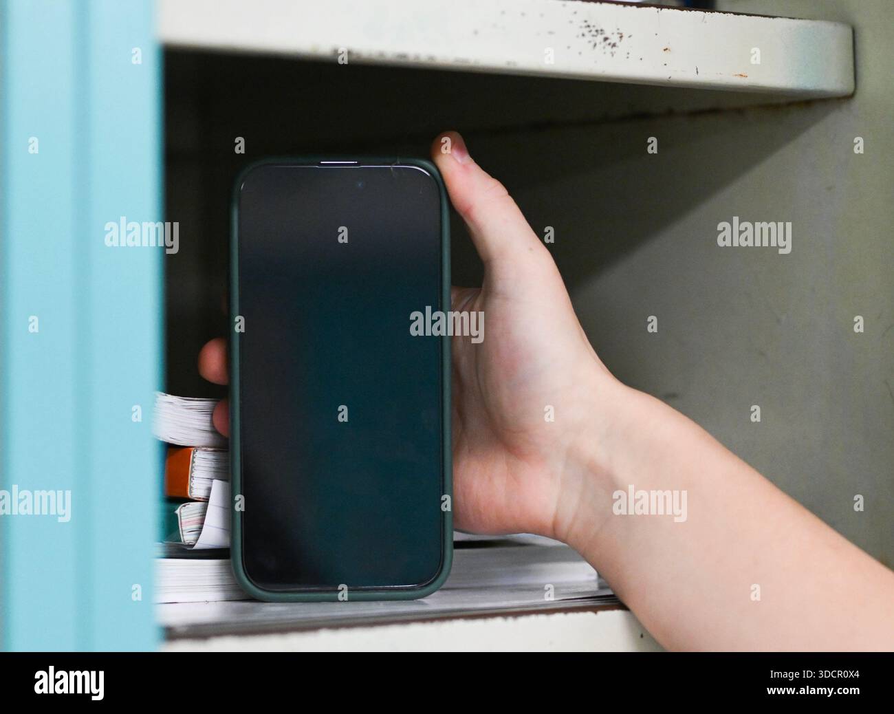 A student takes their phone from their locker at Mgr-Parent secondary ...
