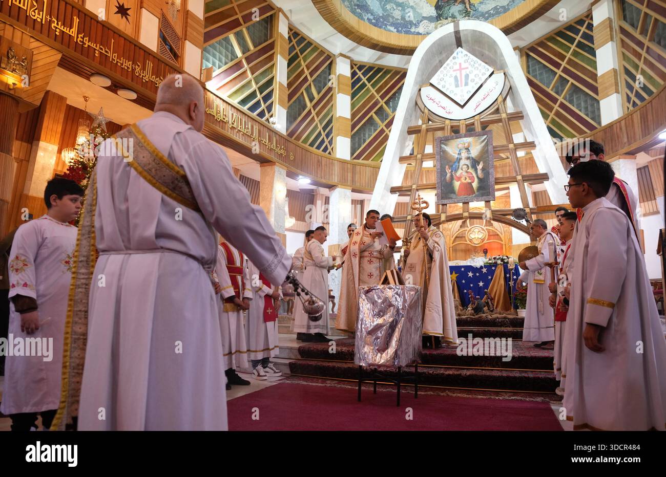Iraqi priest Mokhles Shishah, center, leads prayers during Christmas ...