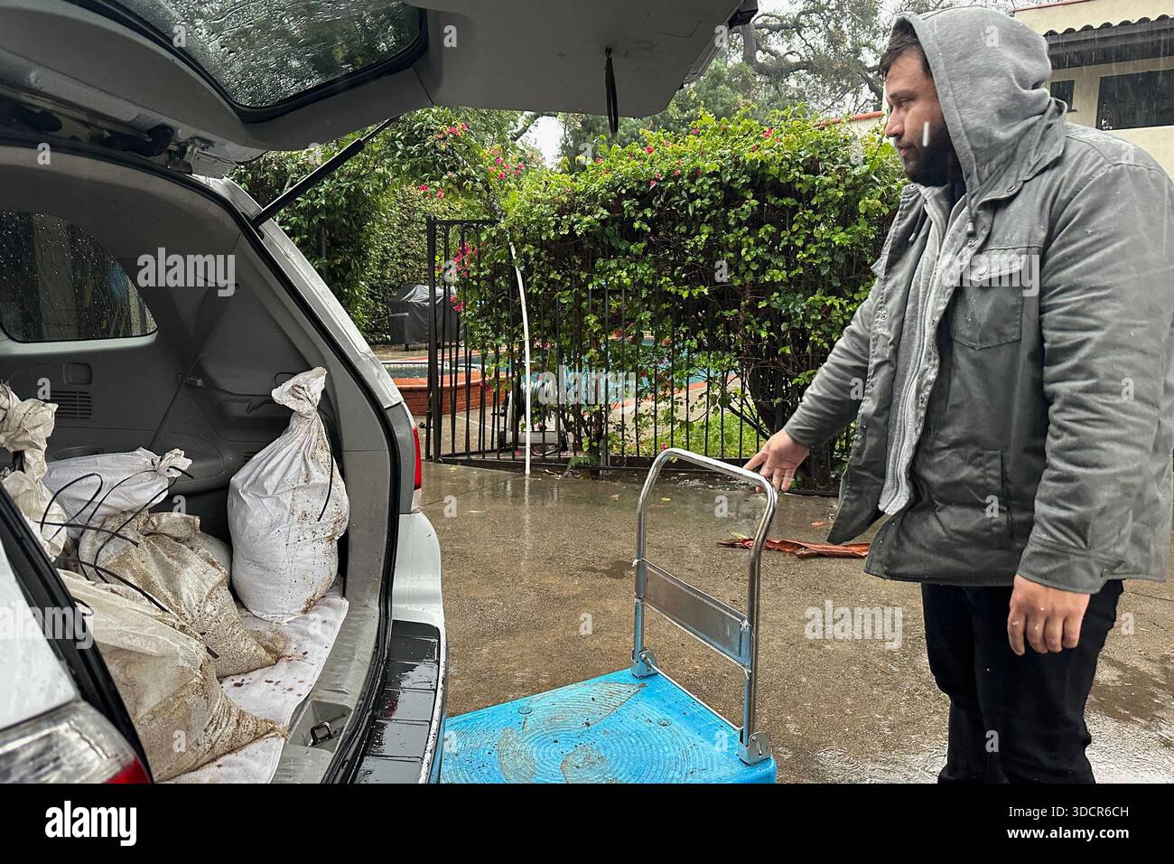 Michael Burdick prepare sandbags around his home in Altadena, Calif ...