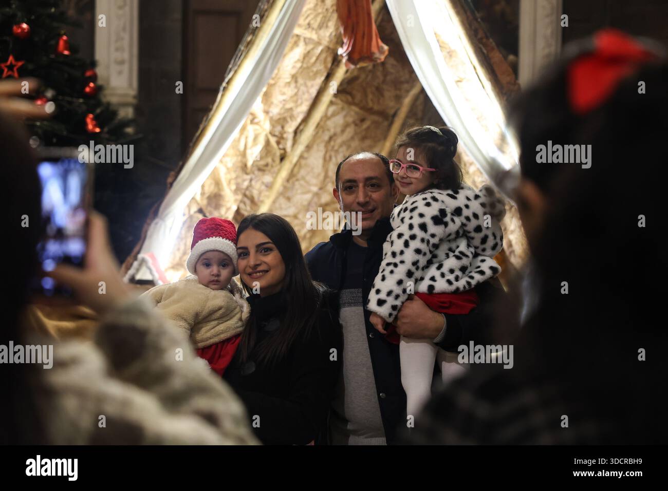 A family poses after a Christmas Eve Mass at the Olive Church in ...