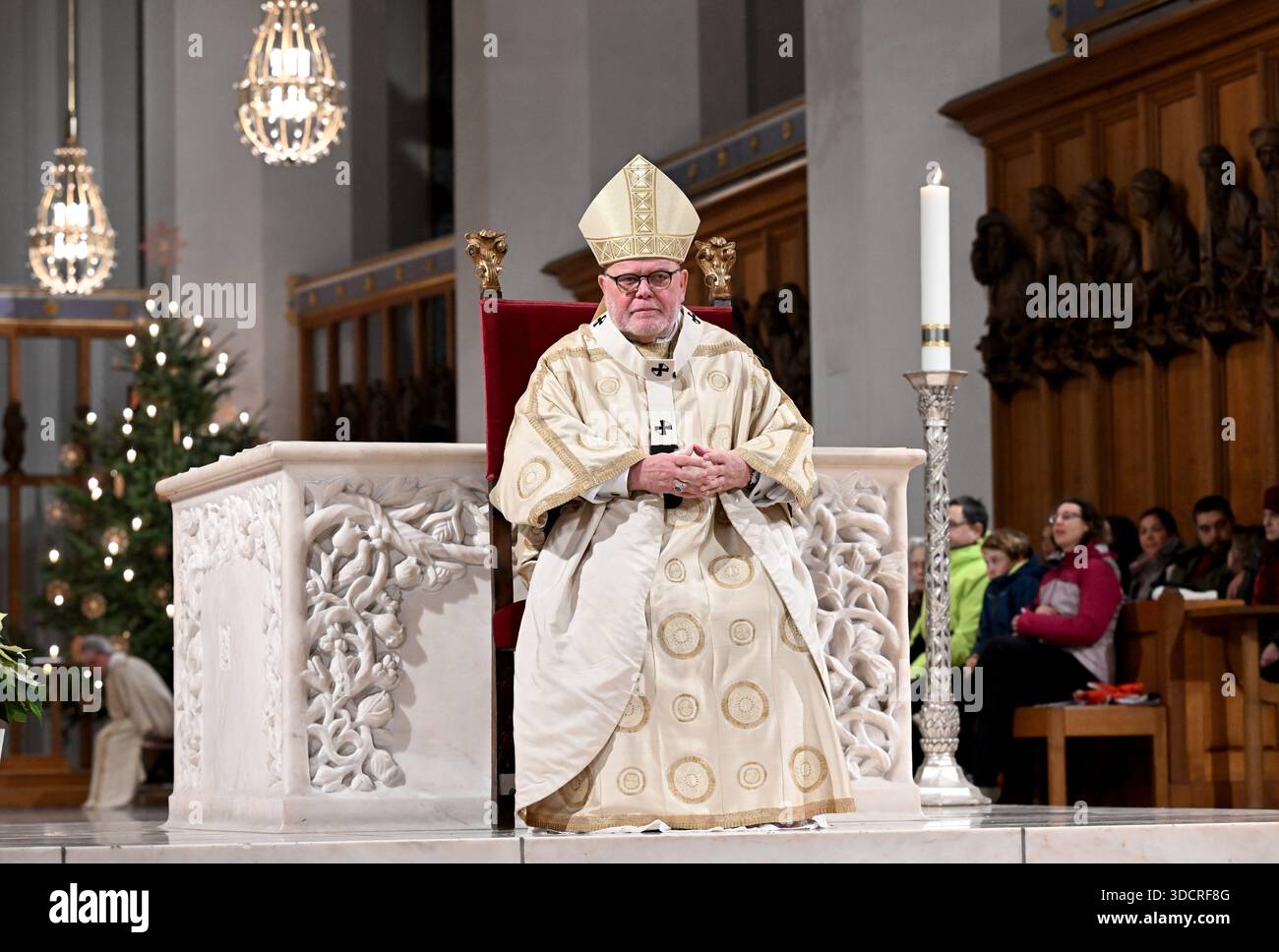 24 December 2025, Bavaria, Munich: Cardinal Reinhard Marx sits in front ...