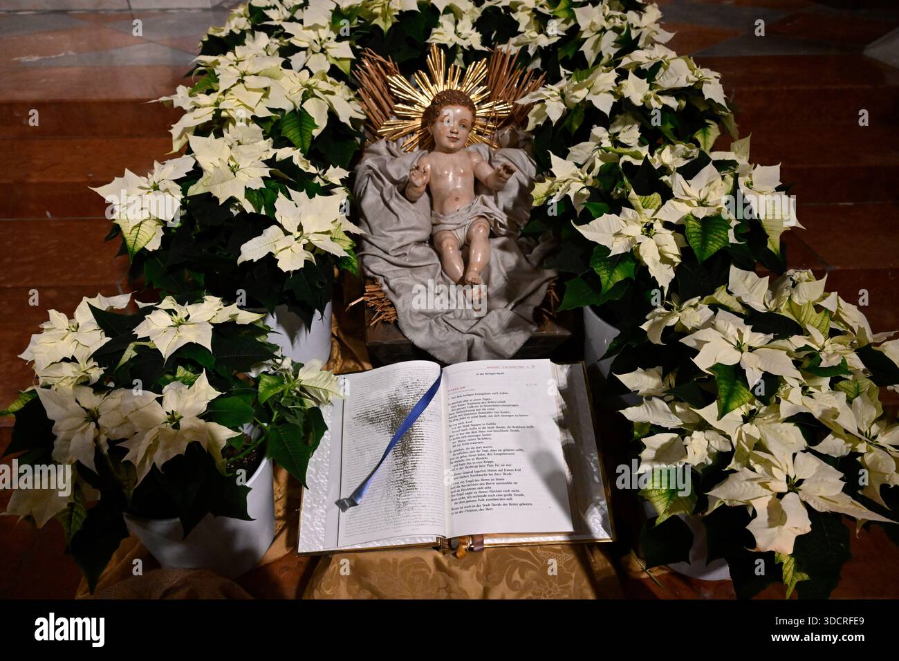 24 December 2025, Bavaria, Munich: A figure of the Christ Child lies on ...